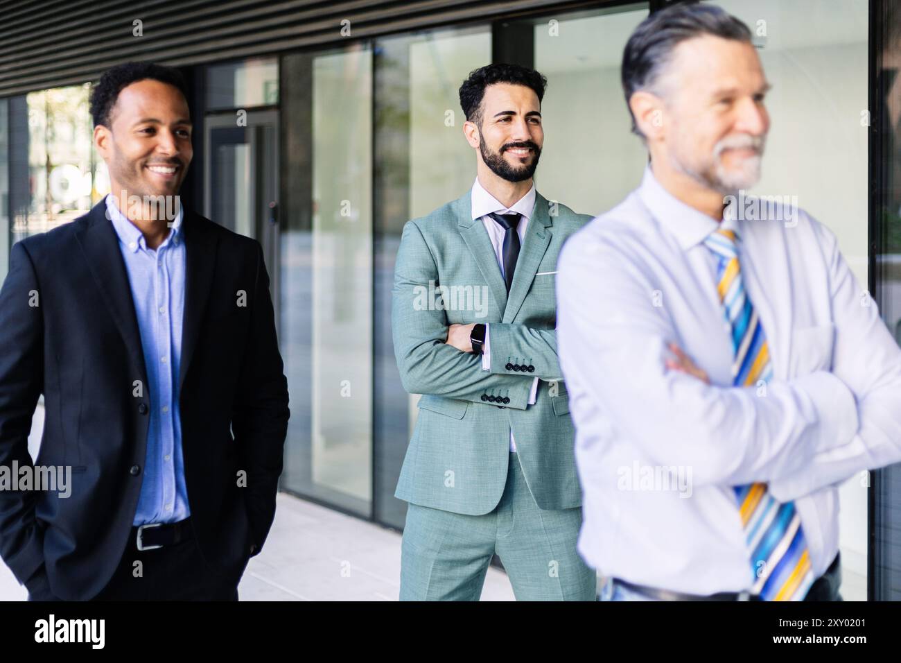 Successful three corporate businessmen team standing together outside ...