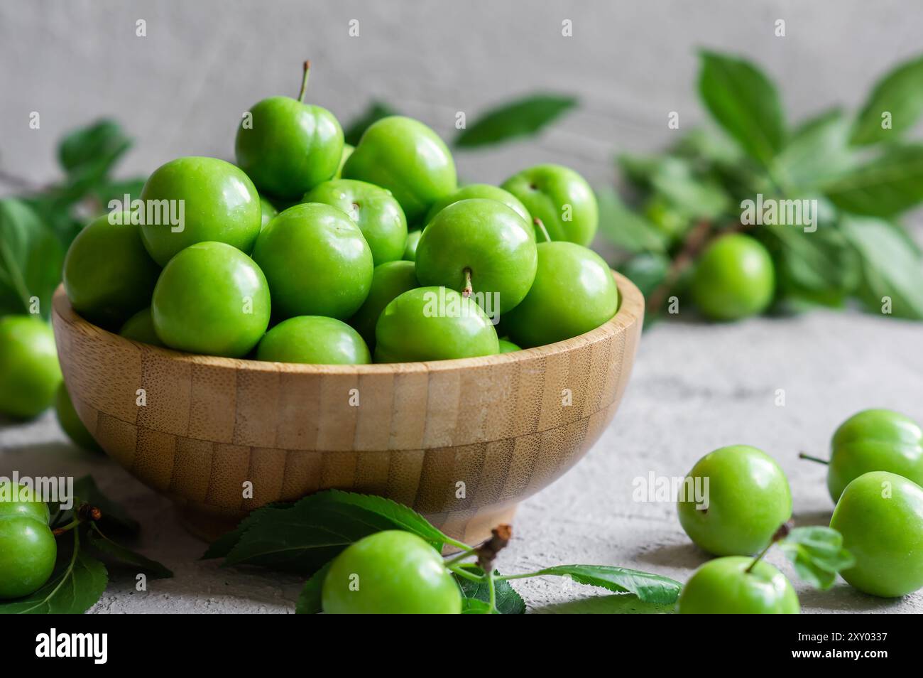 Fresh ripe organic green plums or greengage in bowl on wooden ...