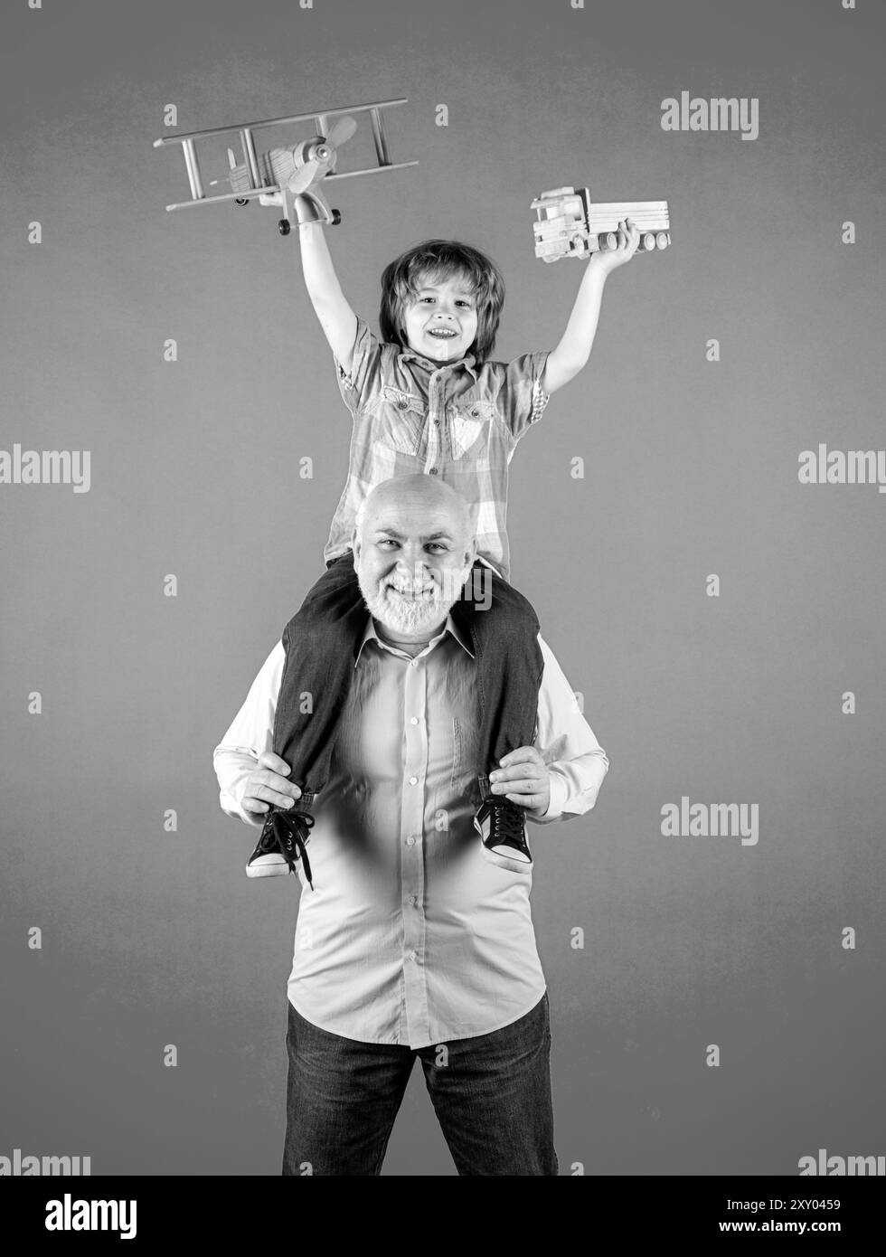 Old grandfather and young child grandson with toy plane and wooden toy ...