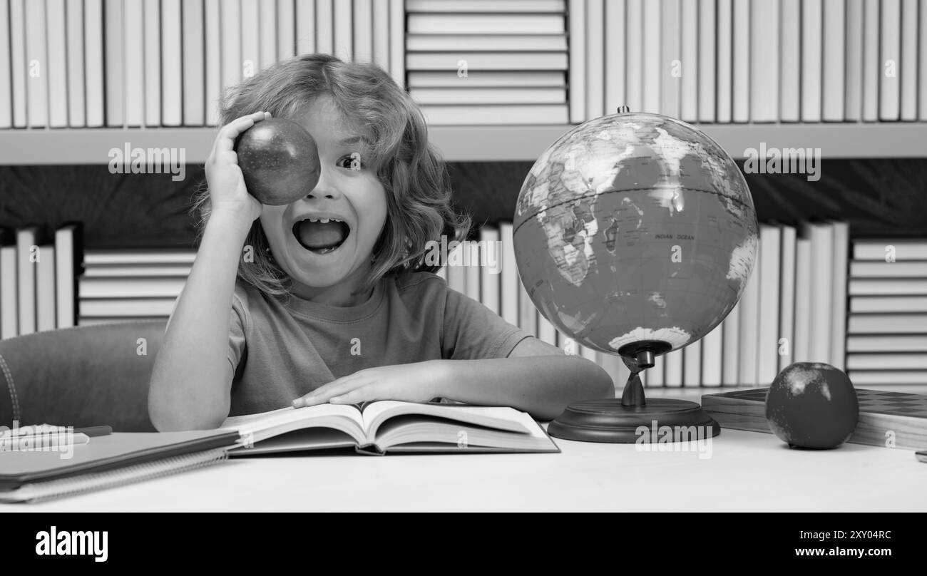 School boy with books and apple in library. Back to school. Funny ...