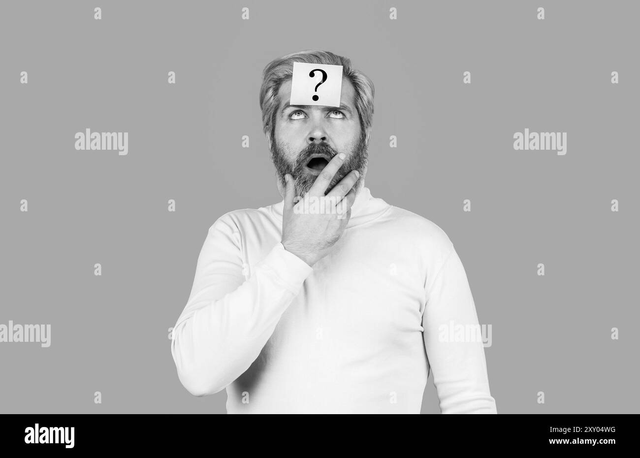 Portrait of young surprised man with question mark on his head ...