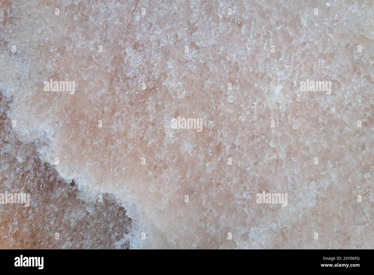 A close-up view of a light pinkish mineral with a crystalline, granular ...