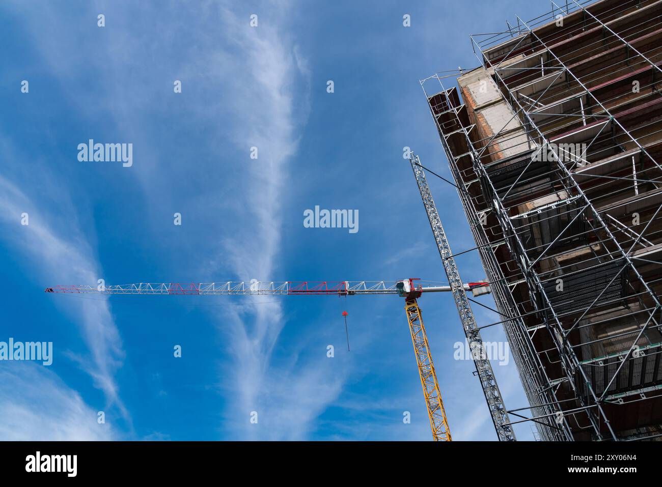 Construction site under a blue sky with a crane and scaffolding in ...