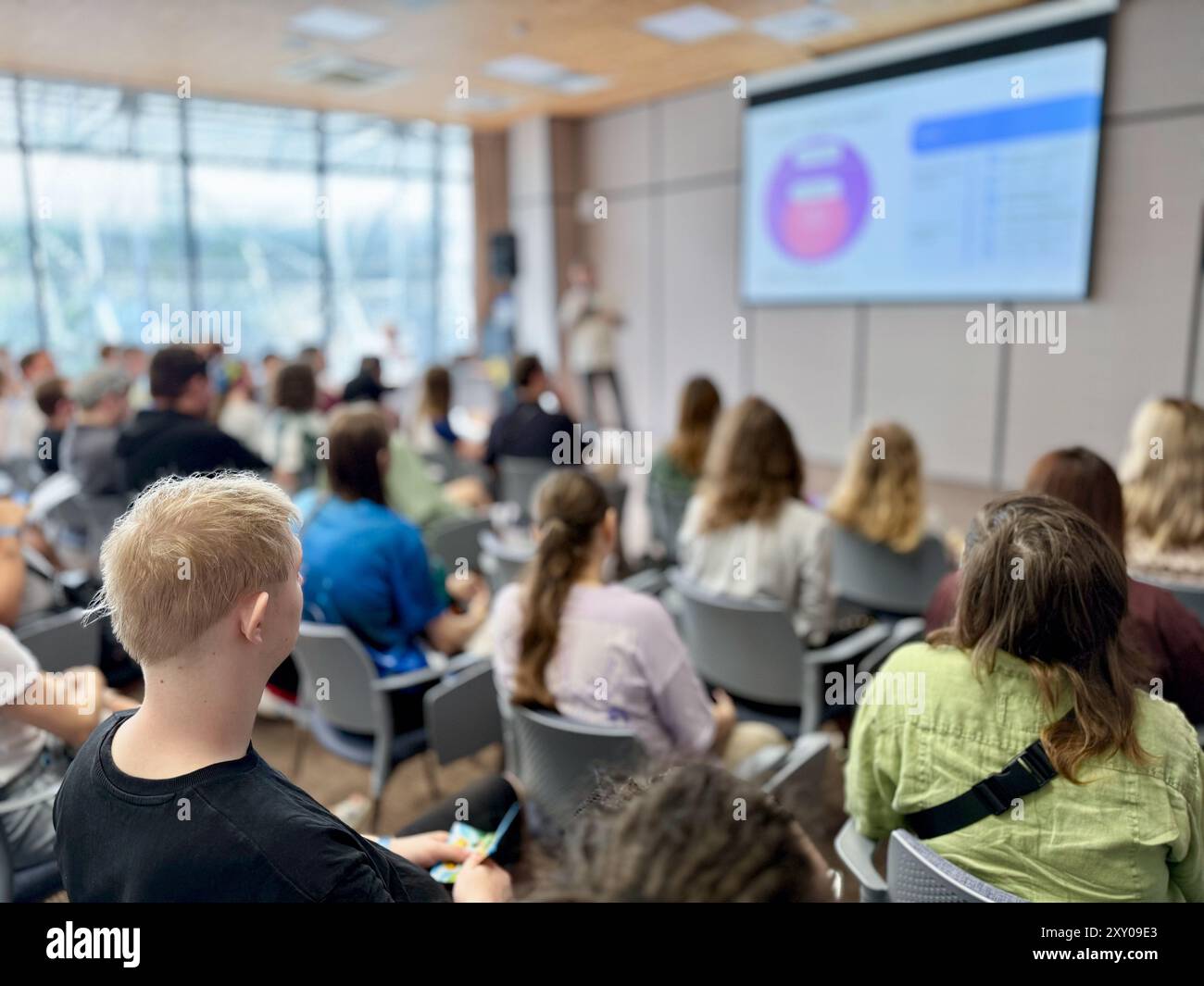 Group of people attending a presentation in a conference room, focusing ...