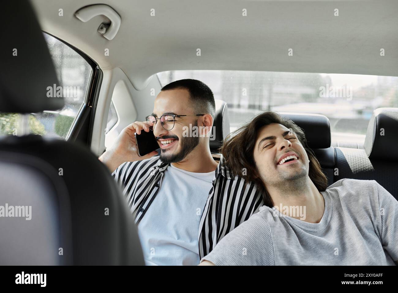 Two men laugh together in the backseat of a car Stock Photo - Alamy