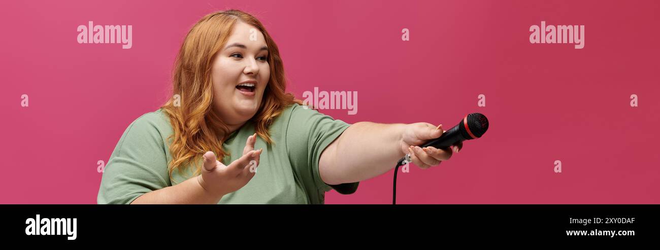 A woman sings into a microphone, smiling and gesturing with her other ...