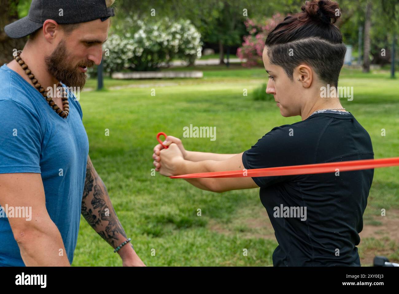 Fitness partners conducting a resistance band workout in a natural park ...