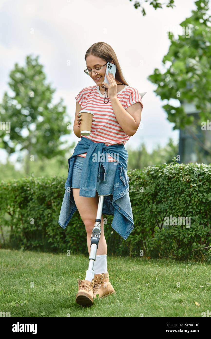 A young woman with a prosthetic leg smiles while talking on the phone ...