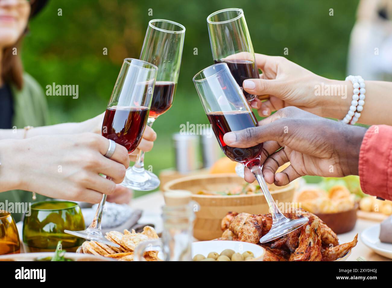 Group of people celebrating at outdoor dinner party with various foods ...