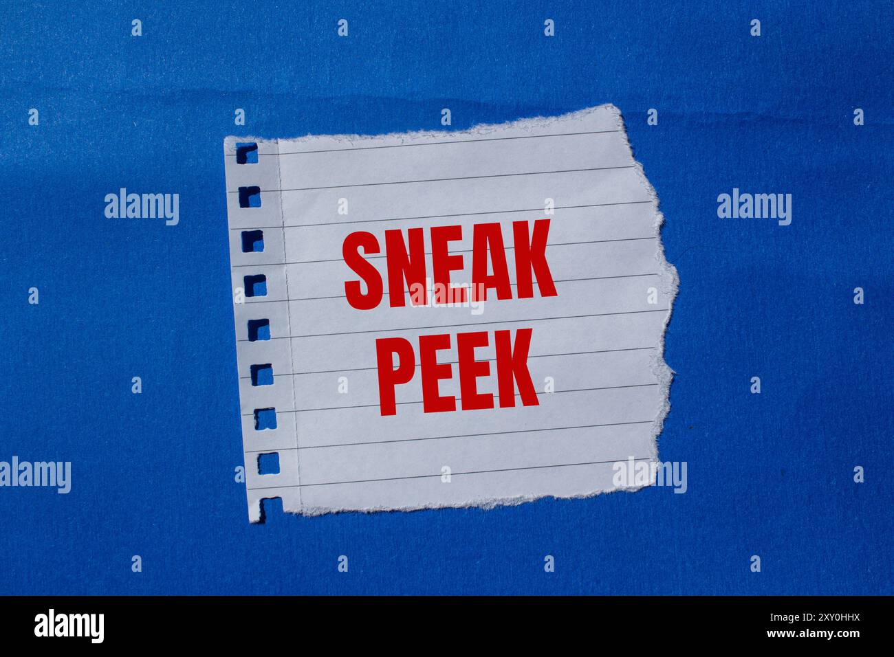 Sneak peek message written on ripped torn paper piece with blue ...