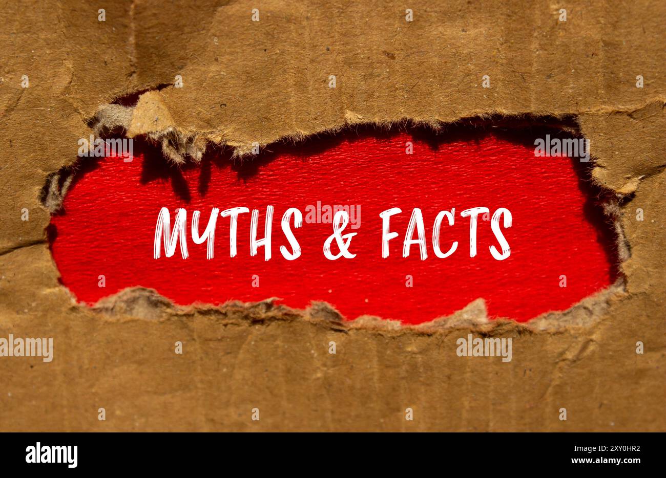 Myths and facts message written on torn cardboard paper with red ...