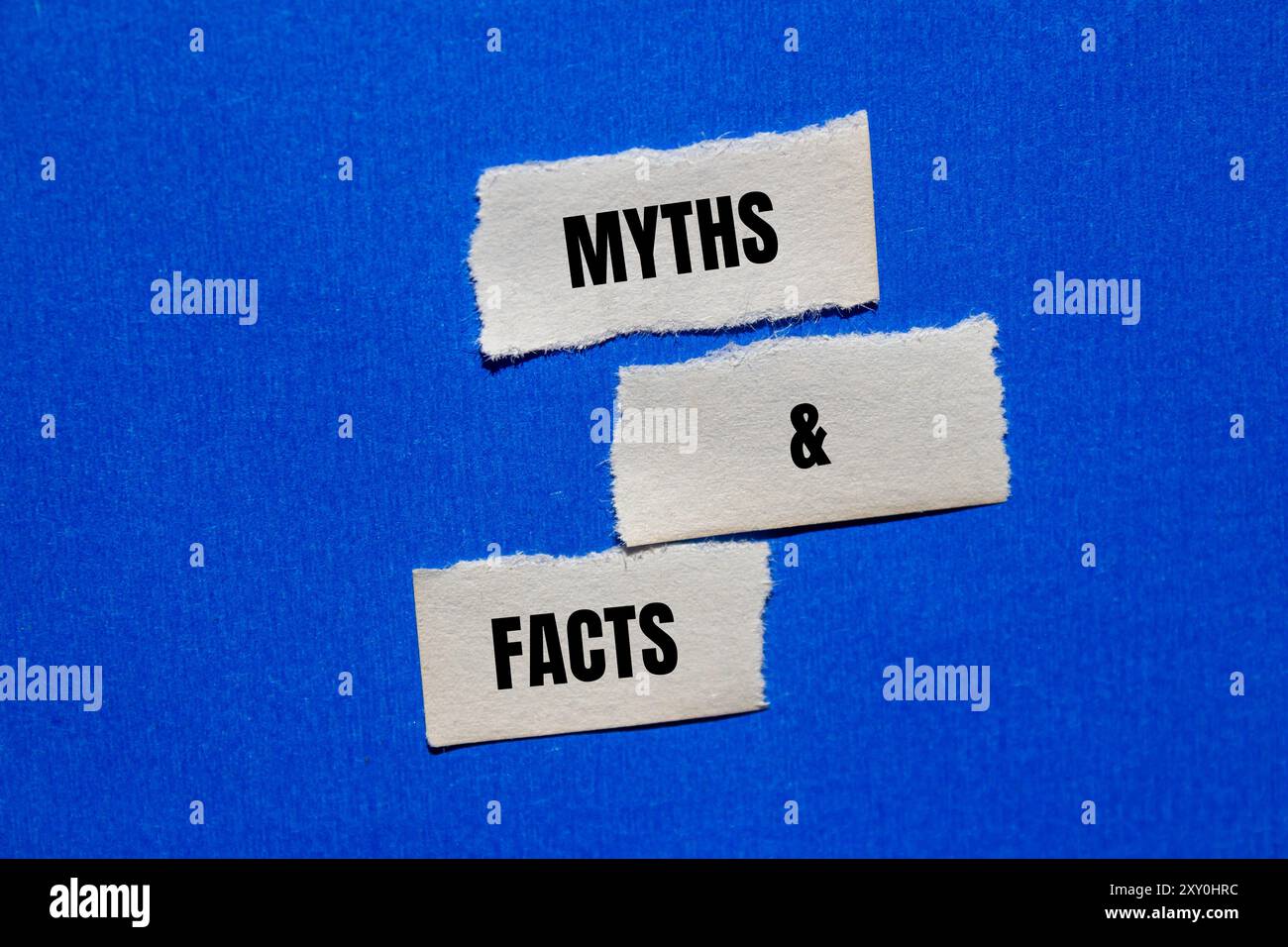 Myths and facts message written on ripped torn paper peices with blue ...