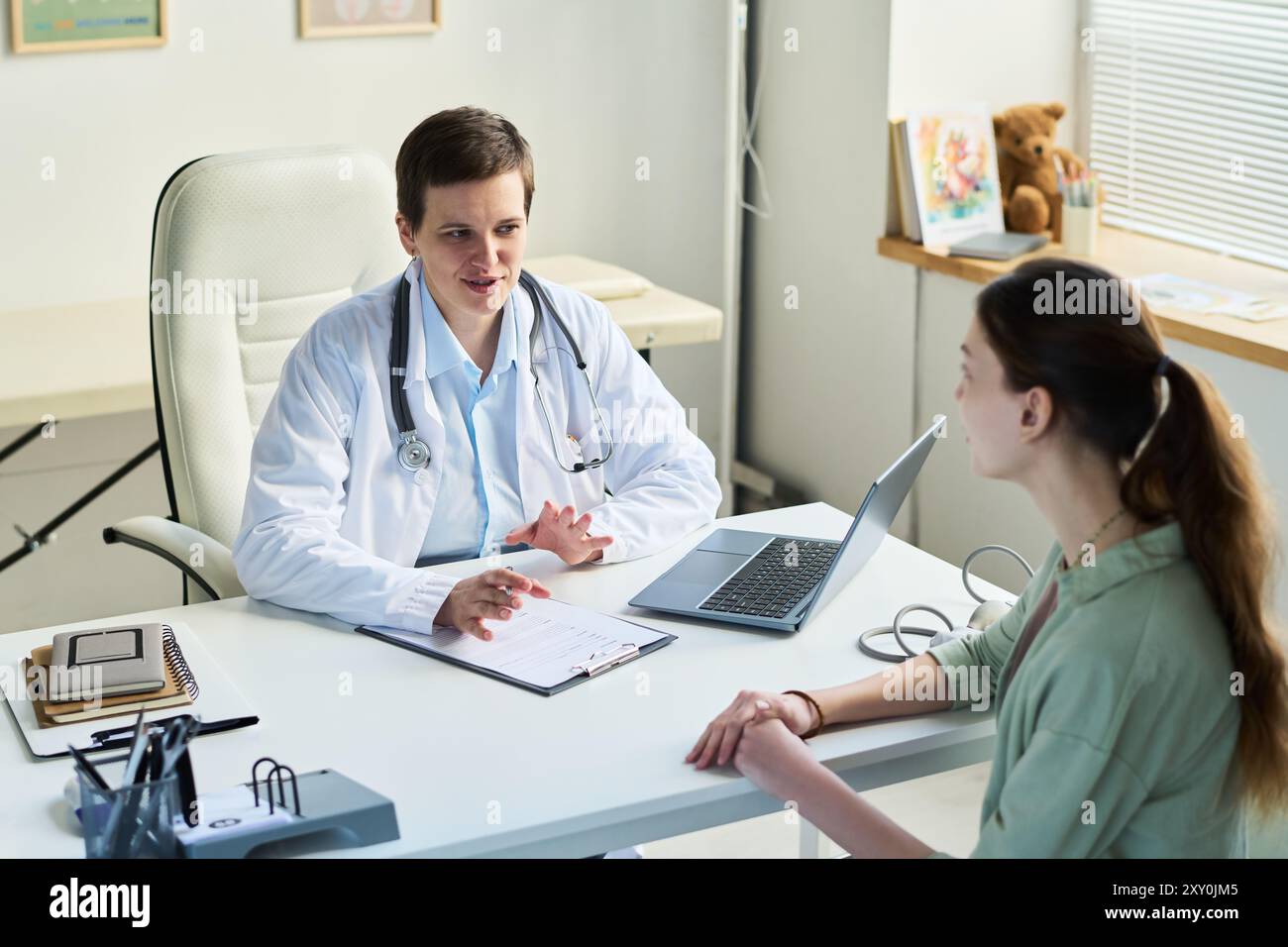 Doctor consulting patient in modern medical office, discussing health ...