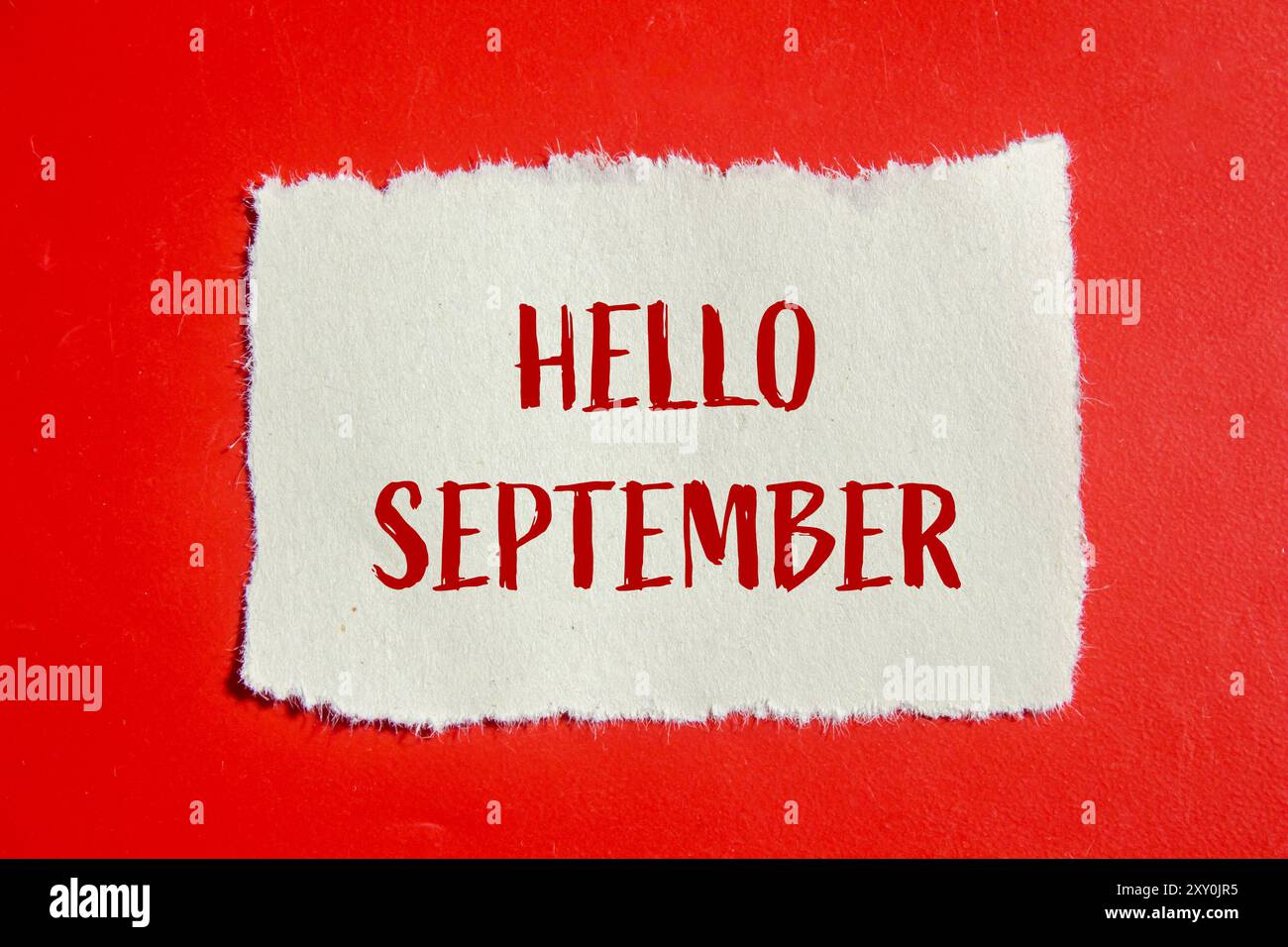 Hello september message written on ripped torn paper piece with red ...