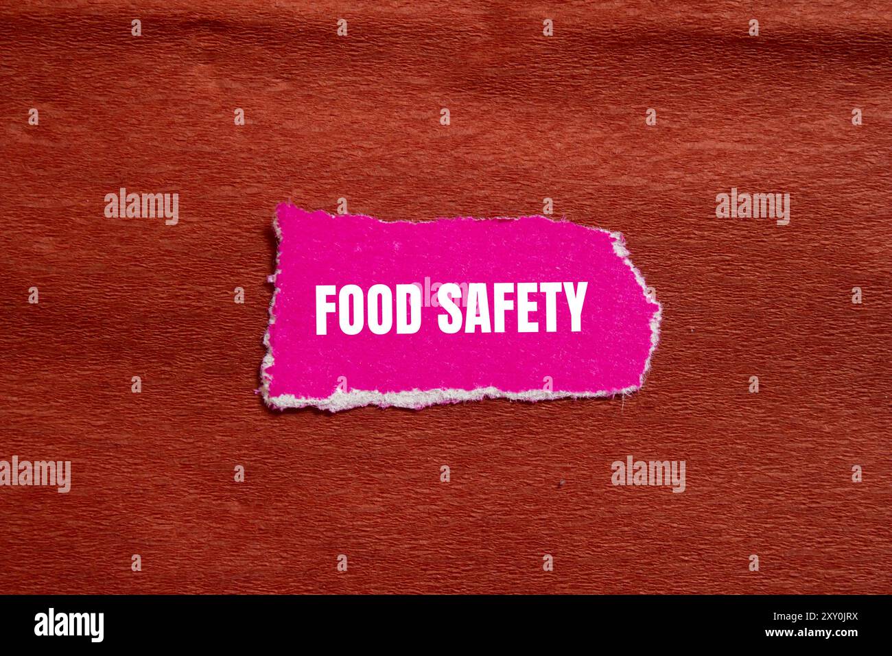 Food safety message written on ripped torn pink paper piece with brown ...
