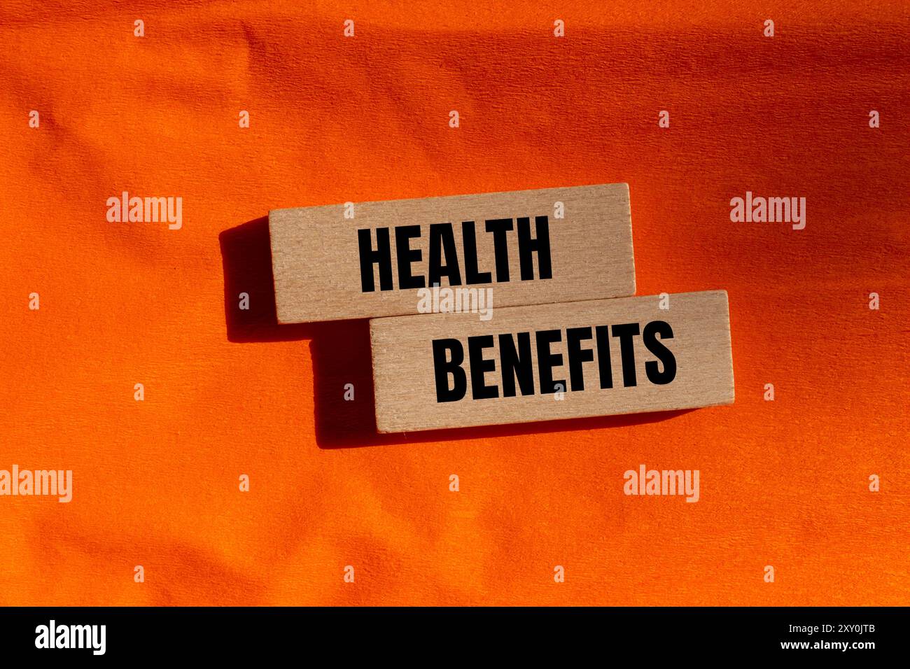 Health benefits message written on wooden blocks with orange background ...