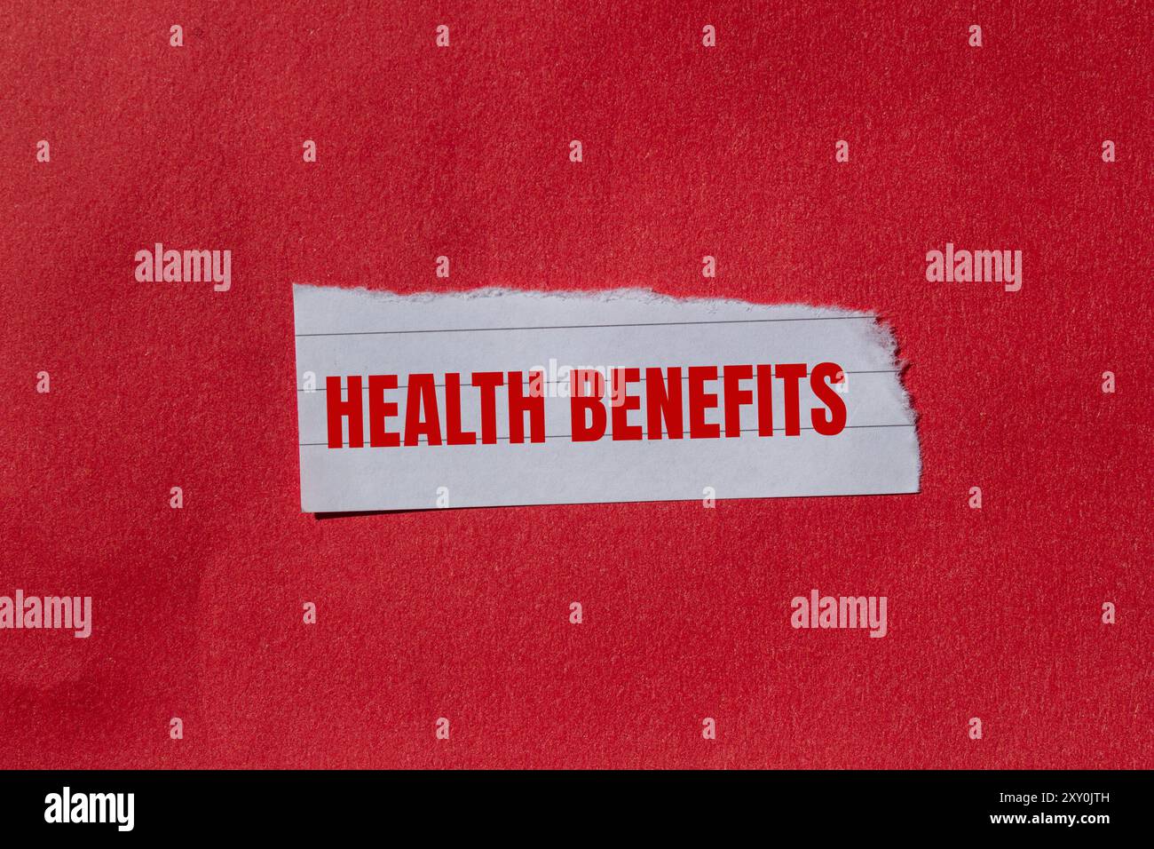 Health benefits message written on ripped torn paper piece with red background. Conceptual ...