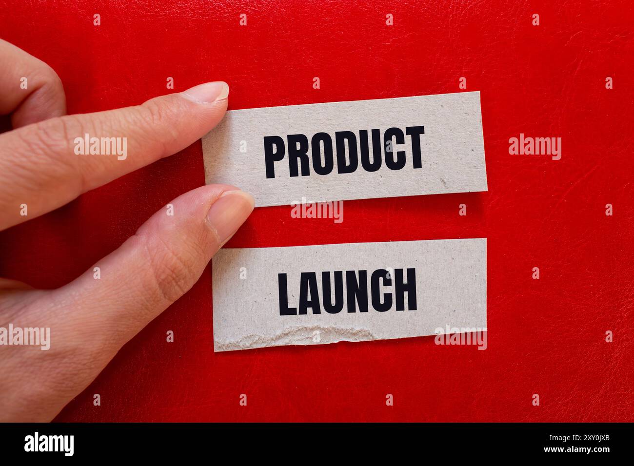 Product launch message written on paper pieces with red background ...