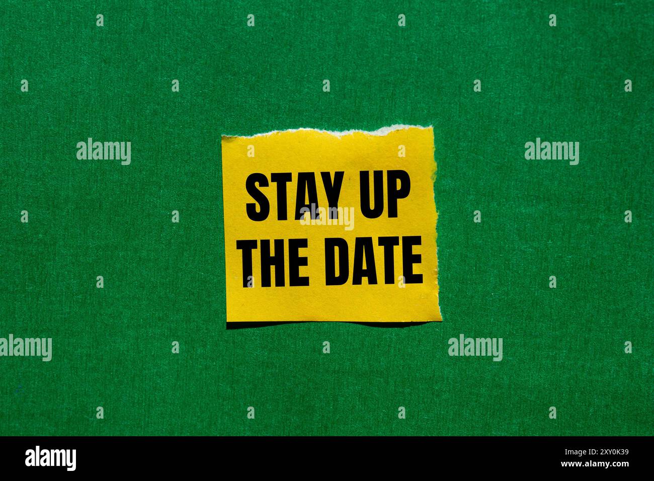 Stay up the date message written on ripped torn yellow paper piece with ...