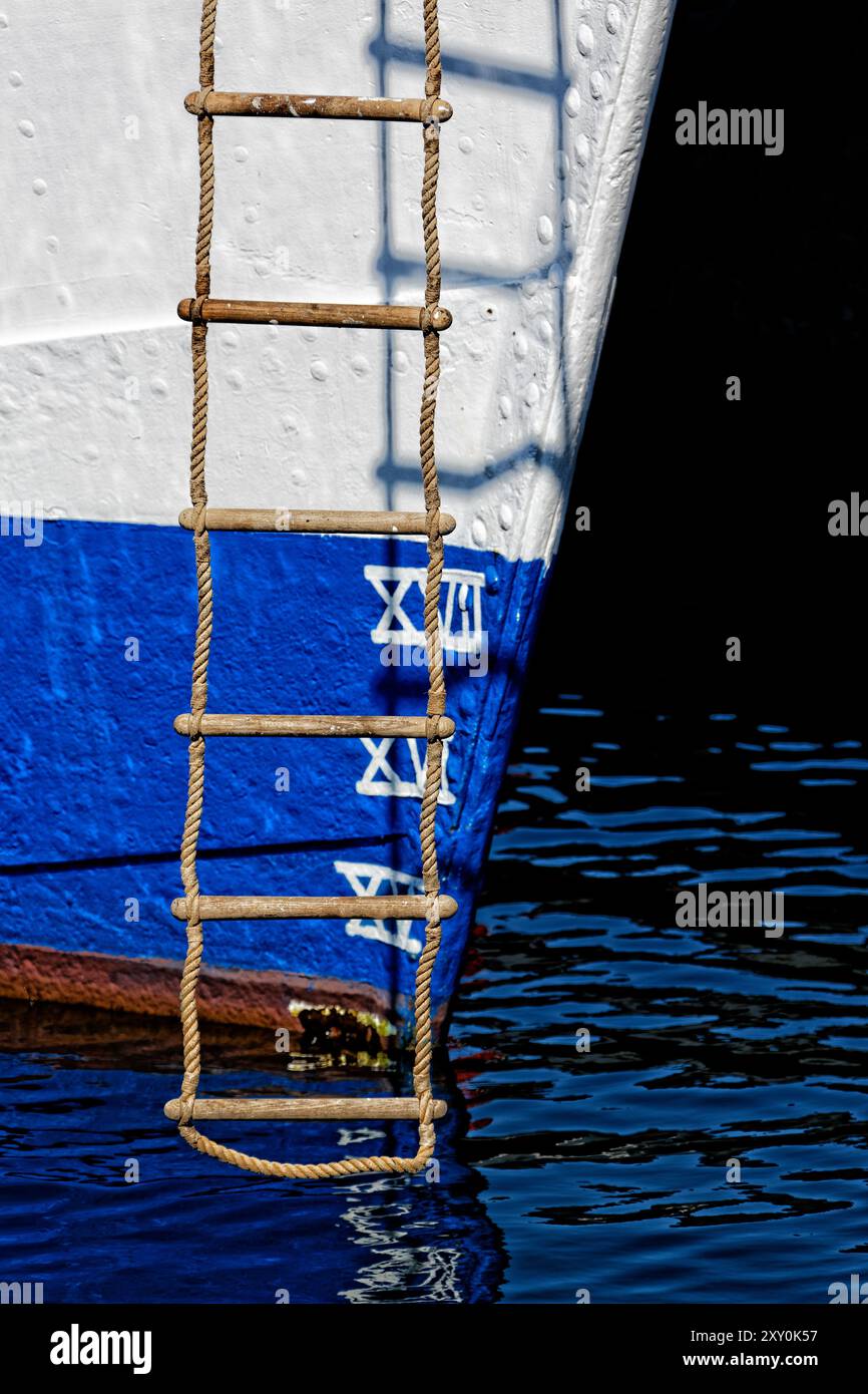 A rope ladder with wooden rungs in front of a white and blue bow ...