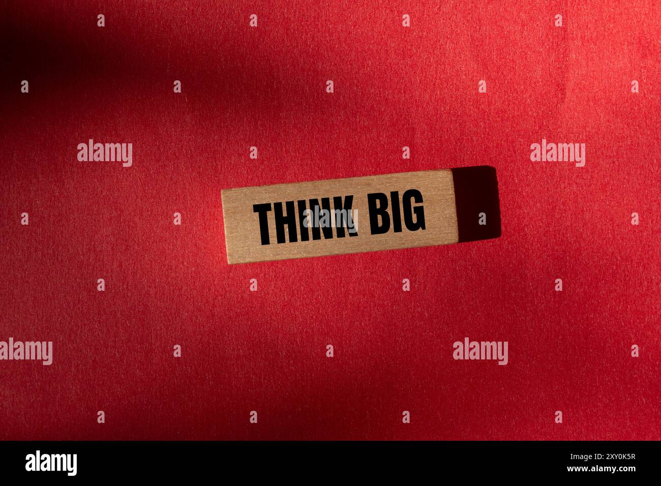 Think big message written on wooden block with red background ...