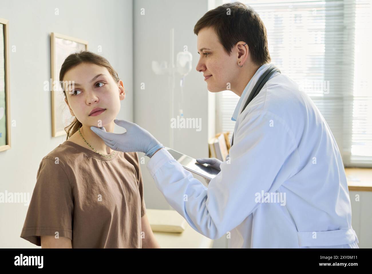 Examining young patient in modern exam room with healthcare ...