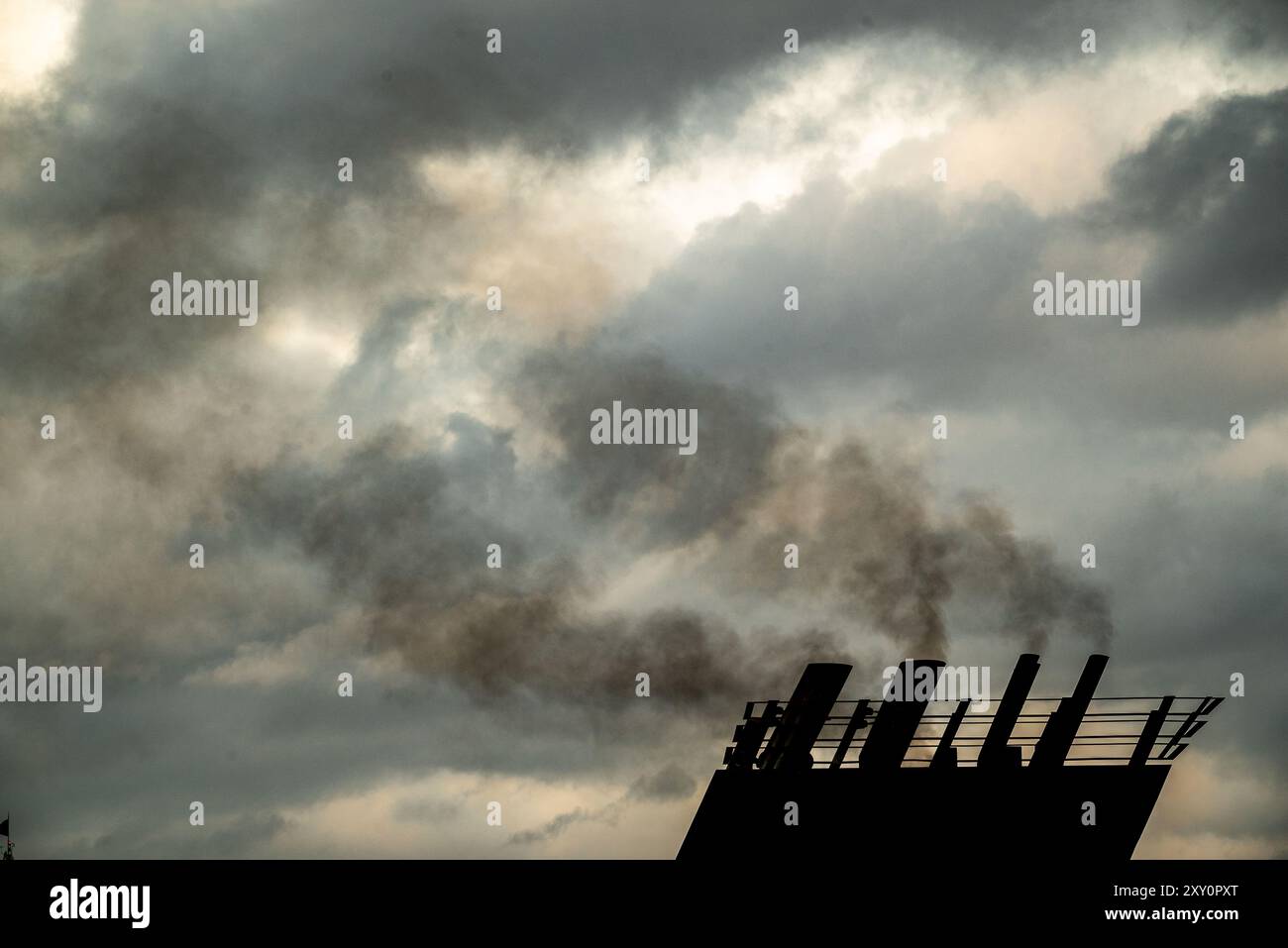 In the port of Barcelona a ferry ship’s funnels gives off smoke ...