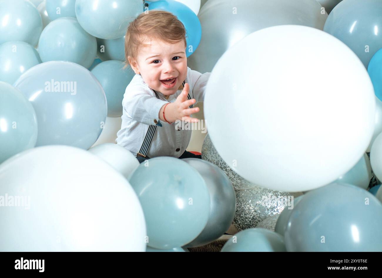 Baby hugging balloons. Kid funny face air balloons. Blue balloons ...