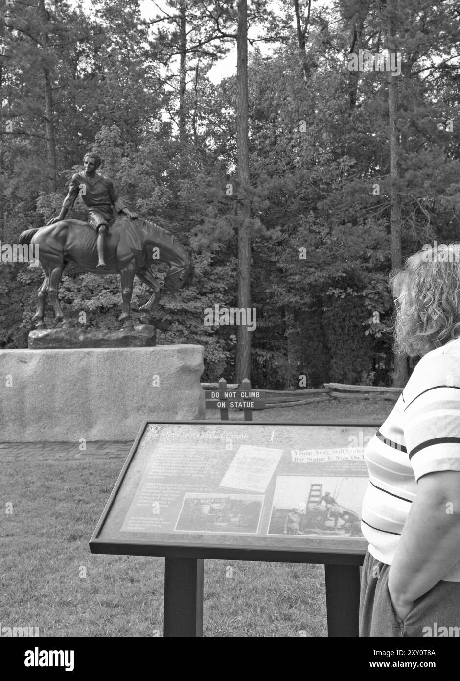 Caucasian female tourist reading information at the statue of a boy on ...