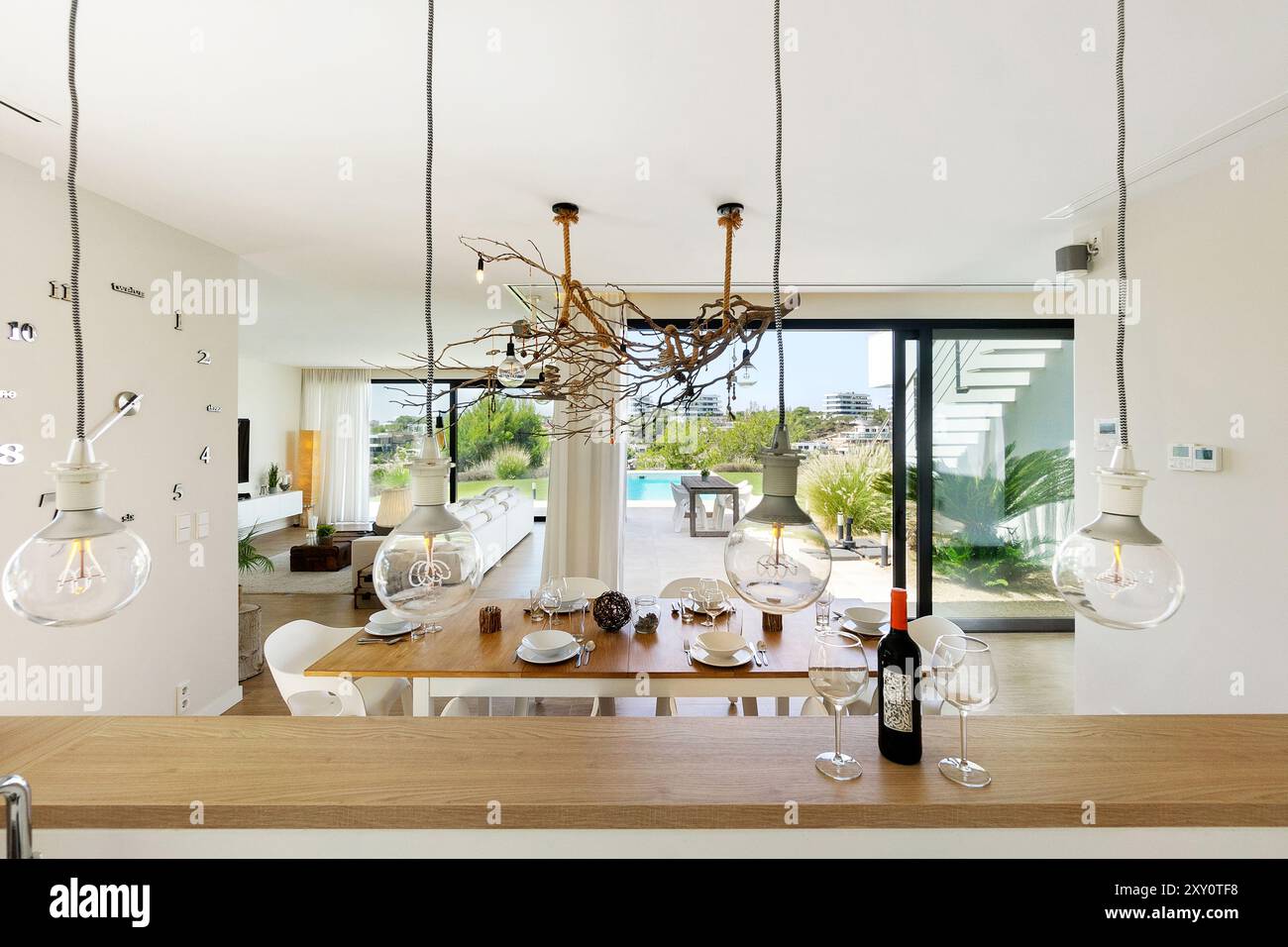 This stylish modern dining room features unique light fixtures and a ...