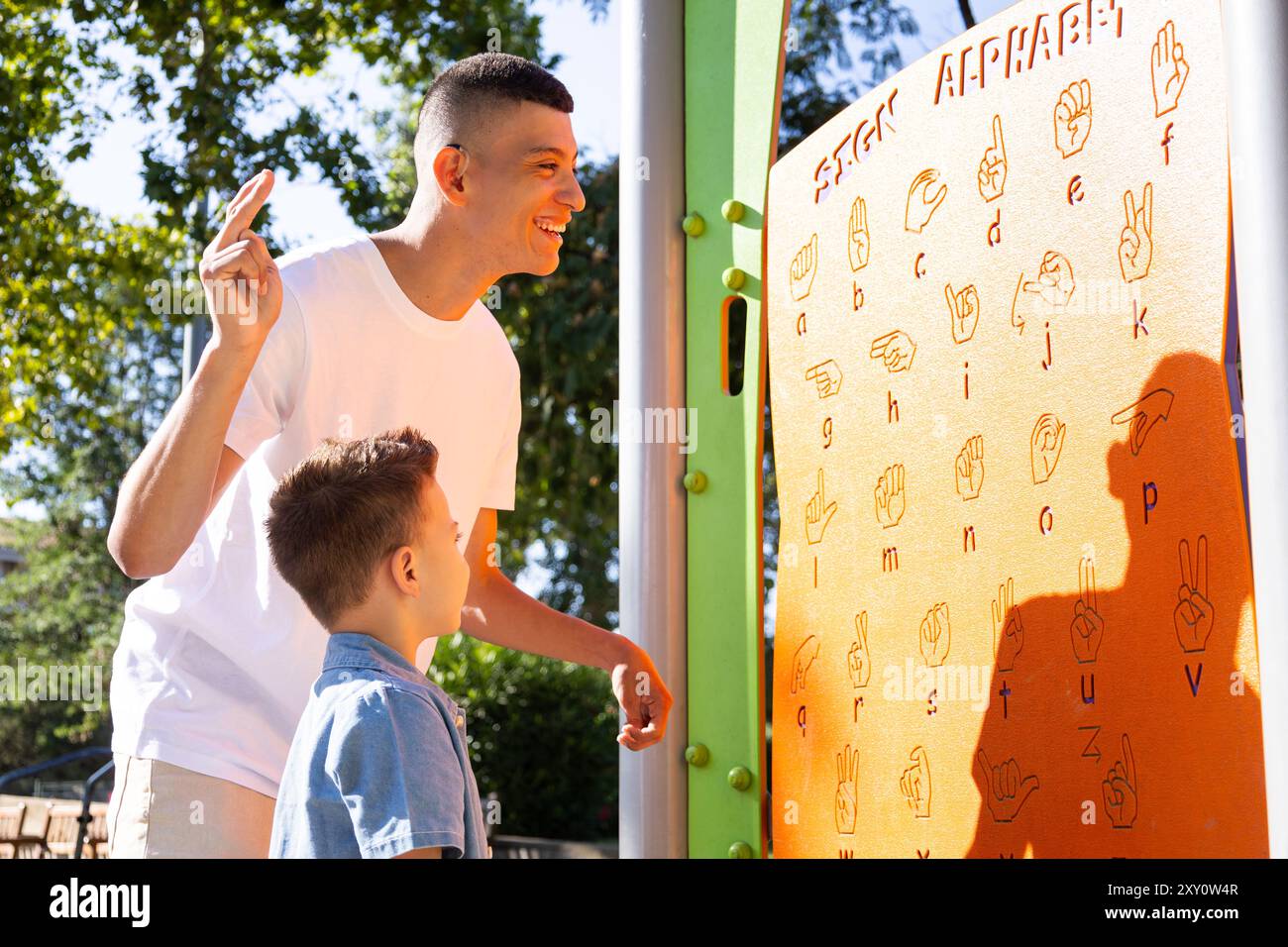 A young man with cerebral palsy and mild deafness joyfully teaches sign ...