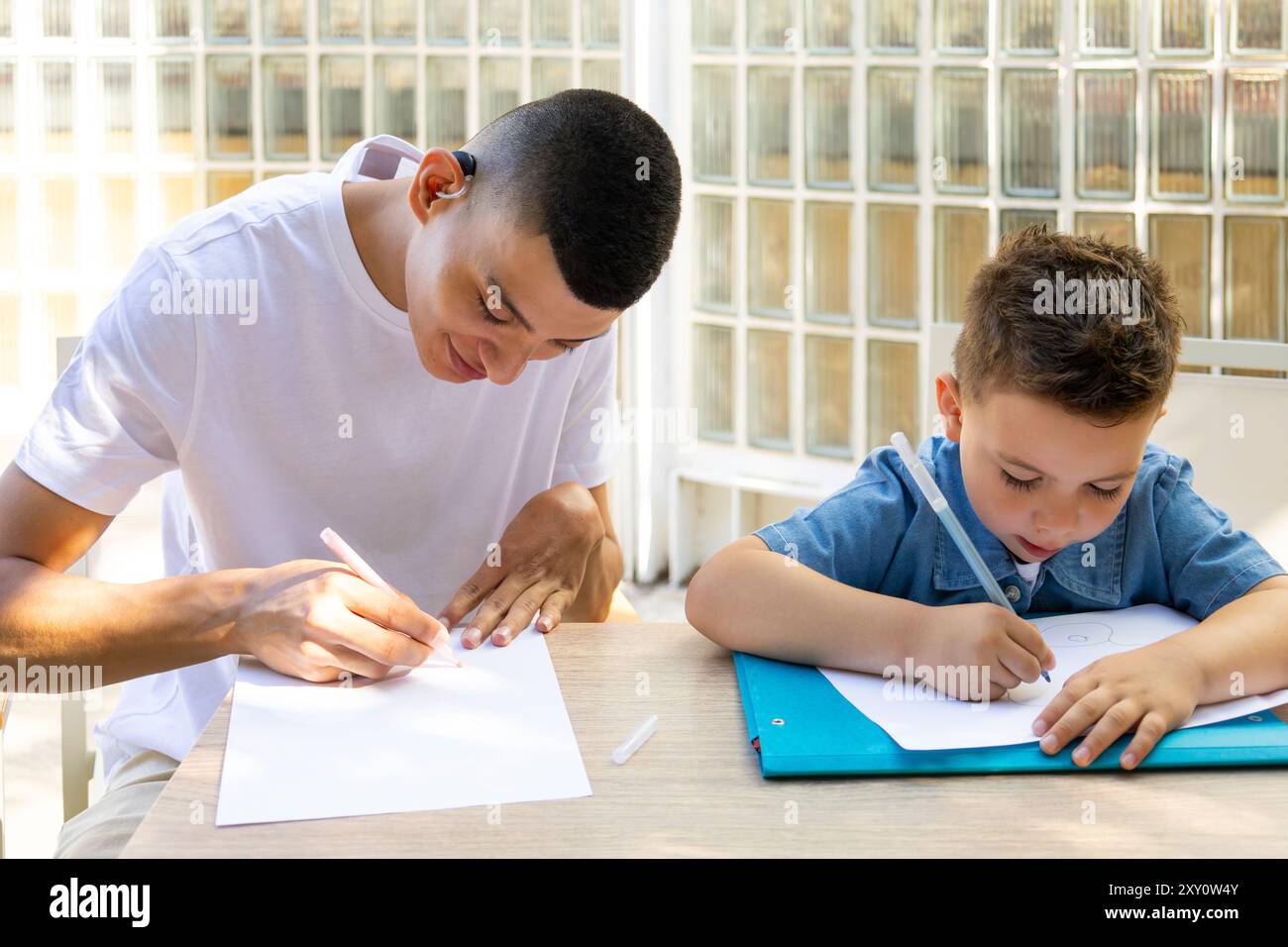 A young man with cerebral palsy and mild deafness mentors a child in ...