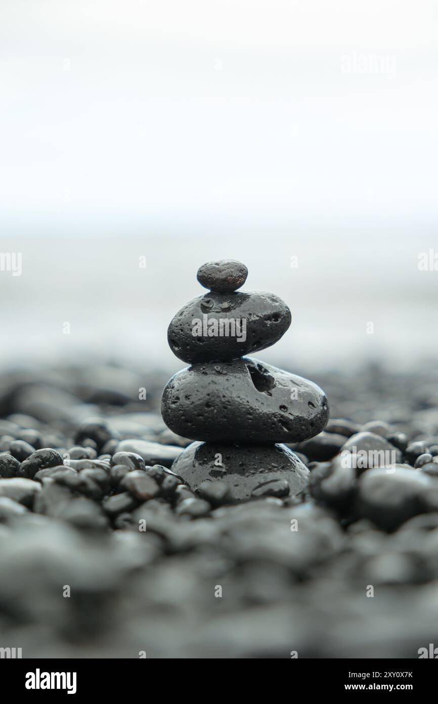 A serene stack of four smooth stones balances perfectly, rising from a ...