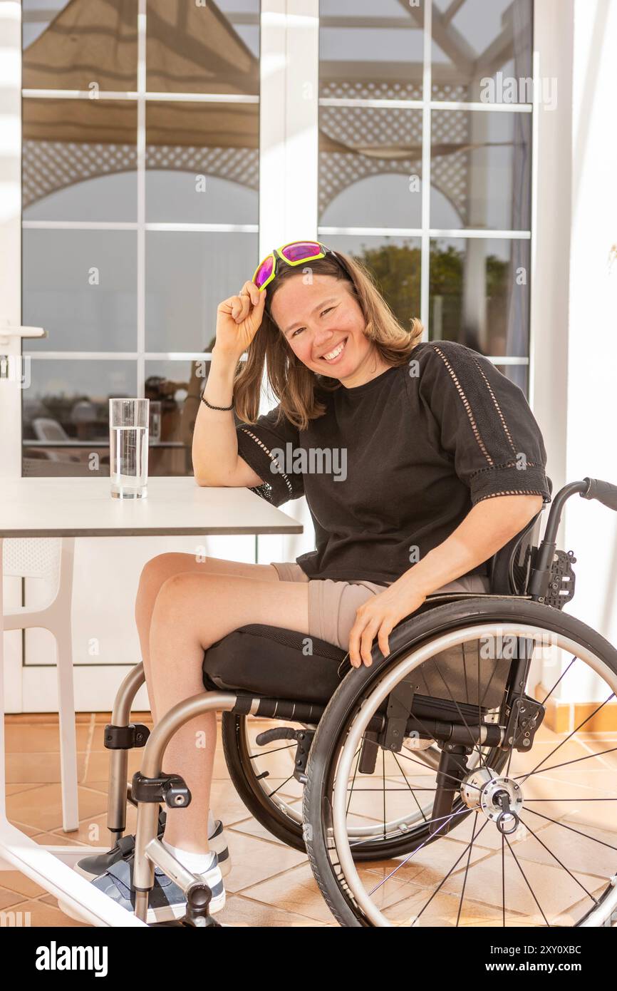 A cheerful woman in a wheelchair smiles while working outdoors ...