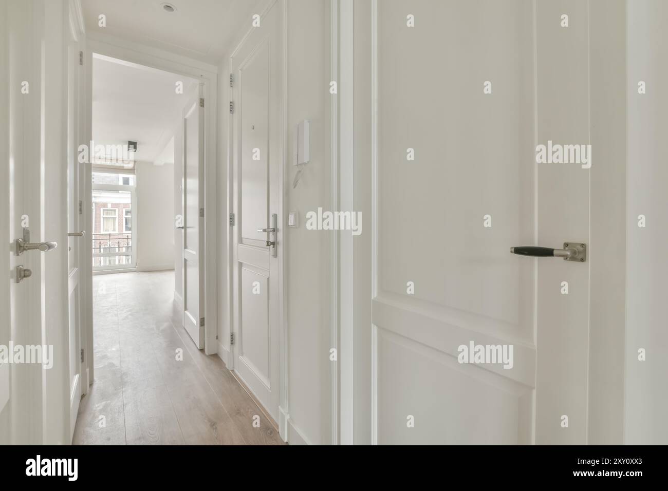 Bright and spacious modern home corridor featuring white doors with ...