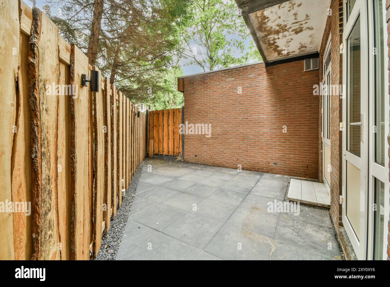 A small, private urban outdoor patio area surrounded by a wooden fence ...