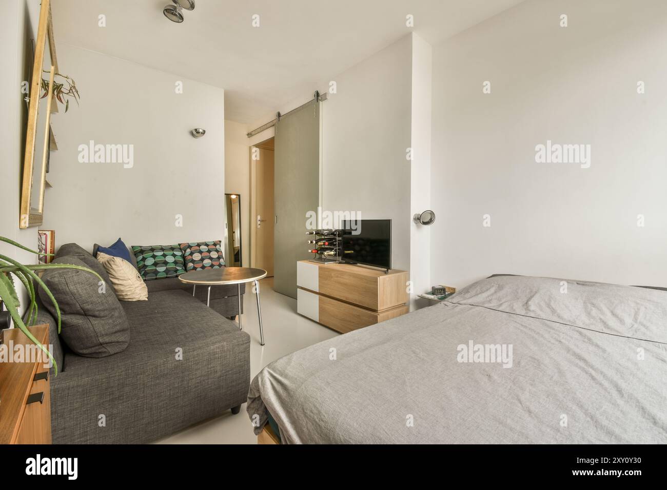 A well-lit modern studio apartment featuring a cozy living area with a ...