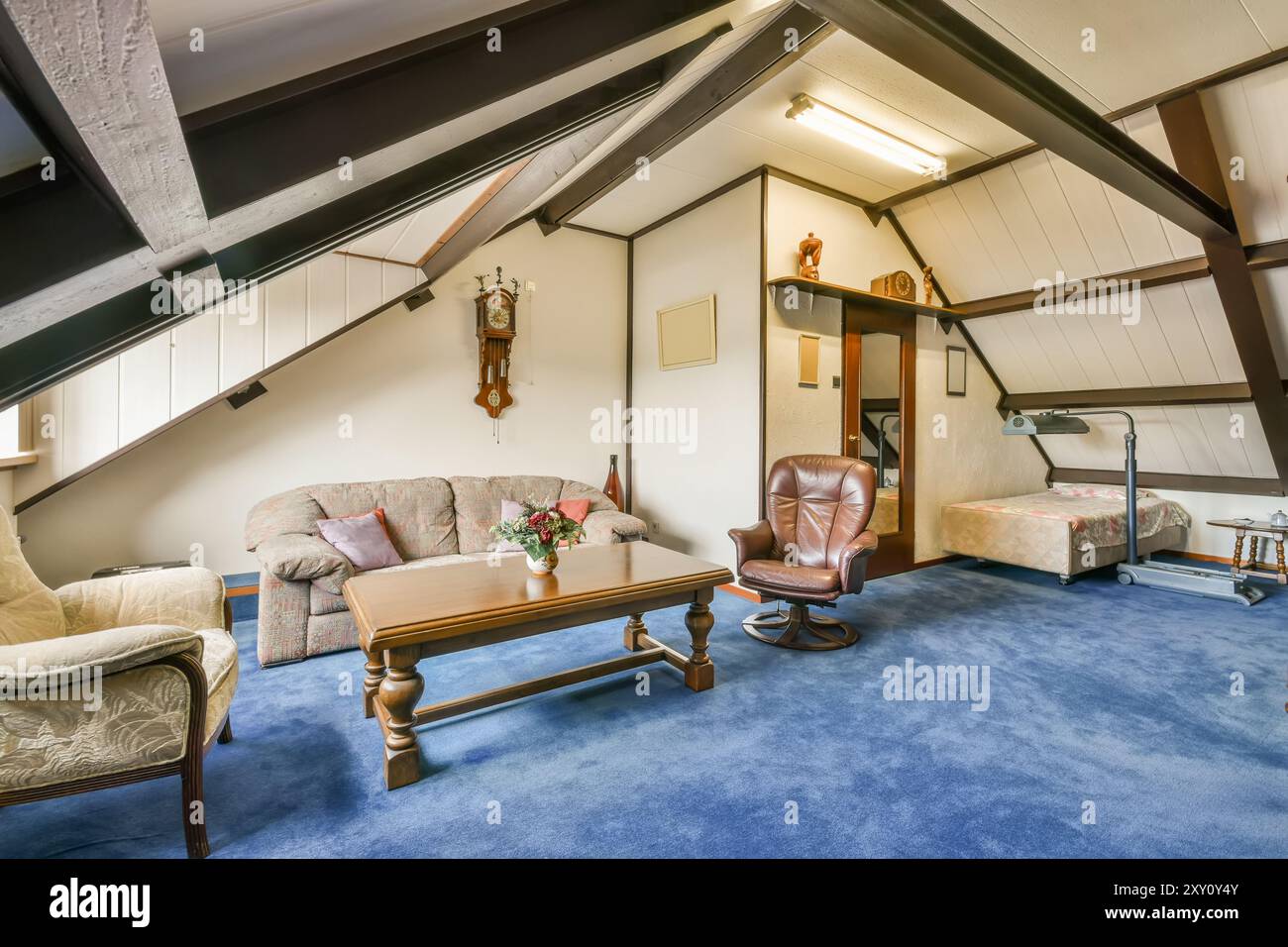 A warmly lit, comfortable attic living area featuring a plush sofa ...