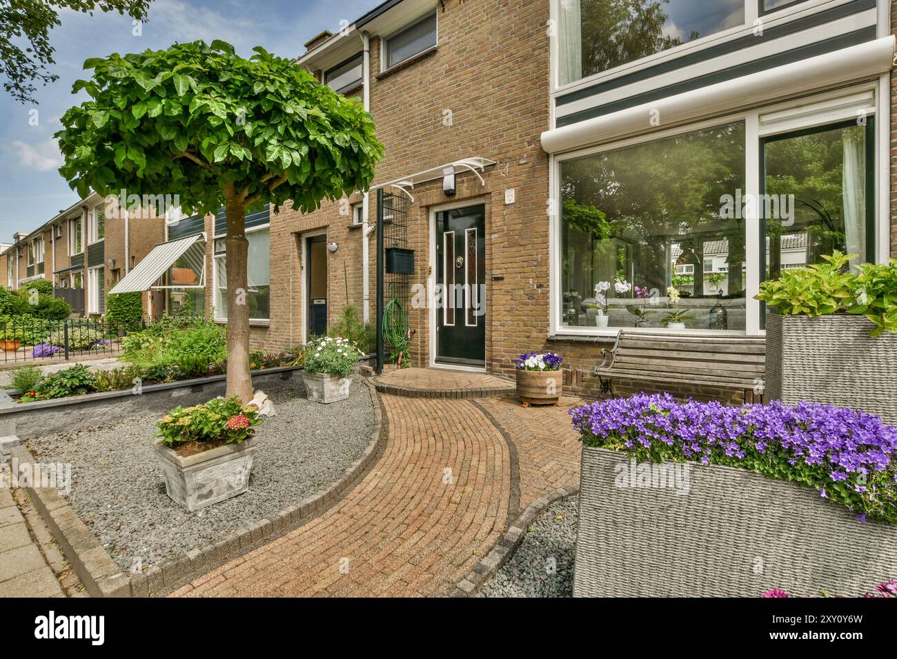 A charming suburban home featuring a beautiful garden with a variety of ...