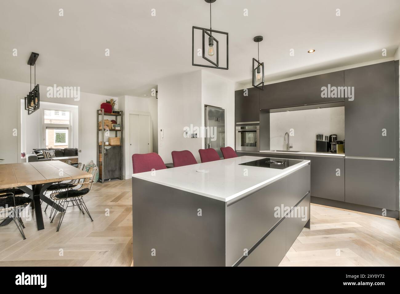 A contemporary kitchen with a central island, bar stools, and a ...