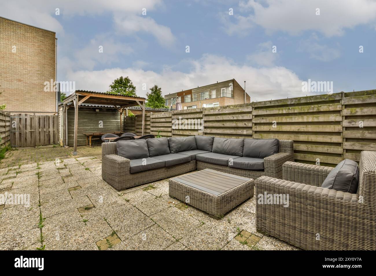 Cozy and inviting backyard setup featuring modern rattan furniture, a ...