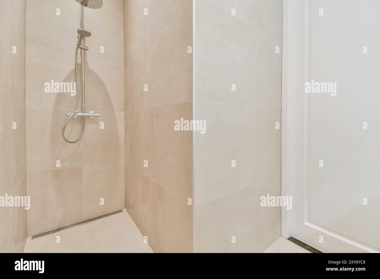 Photo of a contemporary shower with beige tiles and stainless steel ...