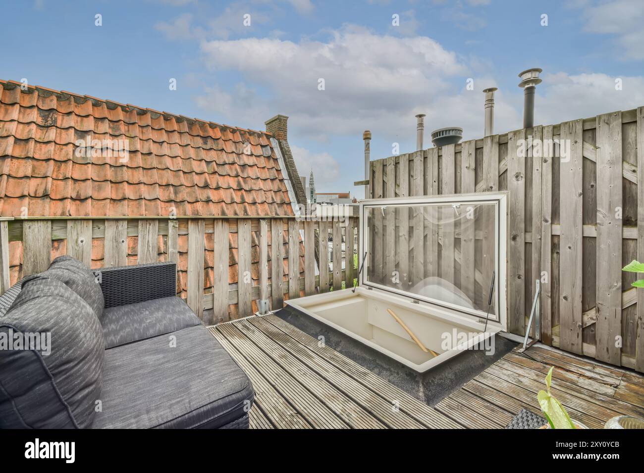 An inviting urban rooftop terrace featuring a wooden deck, skylight ...