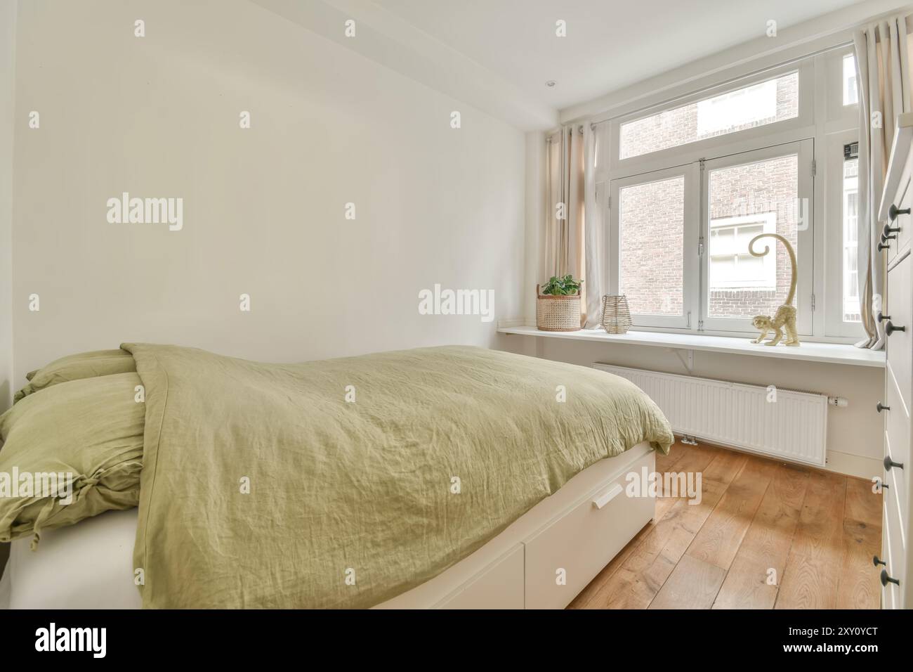 A serene bedroom featuring a comfortable bed with green linen, wooden ...