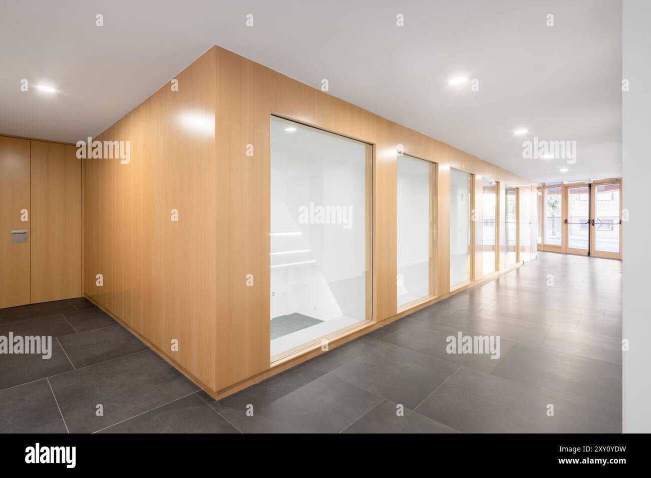 Contemporary design defines this auditorium hallway featuring wooden ...