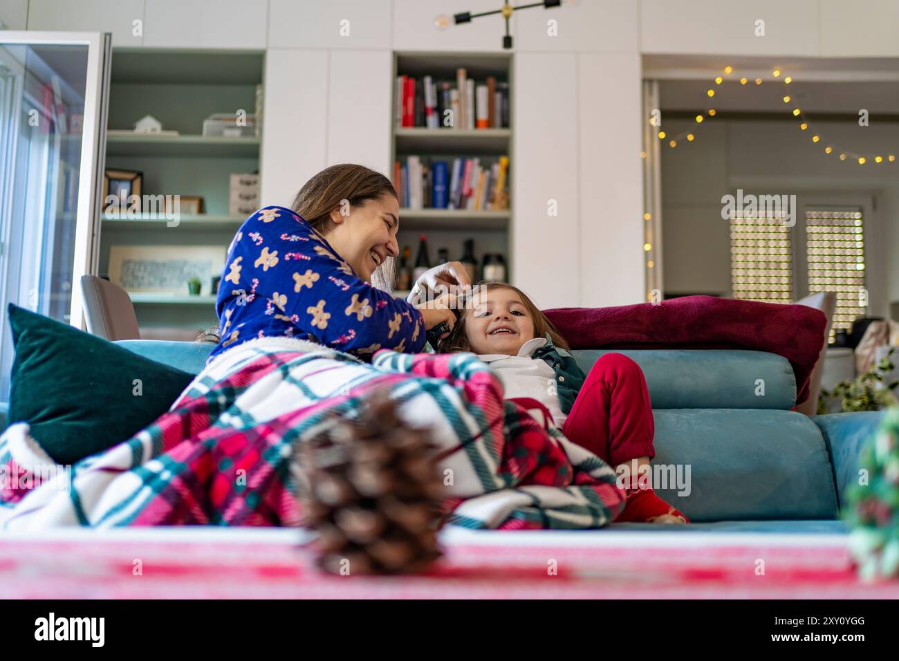A joyful mother and her daughter relax and bond in a cozy home setting ...