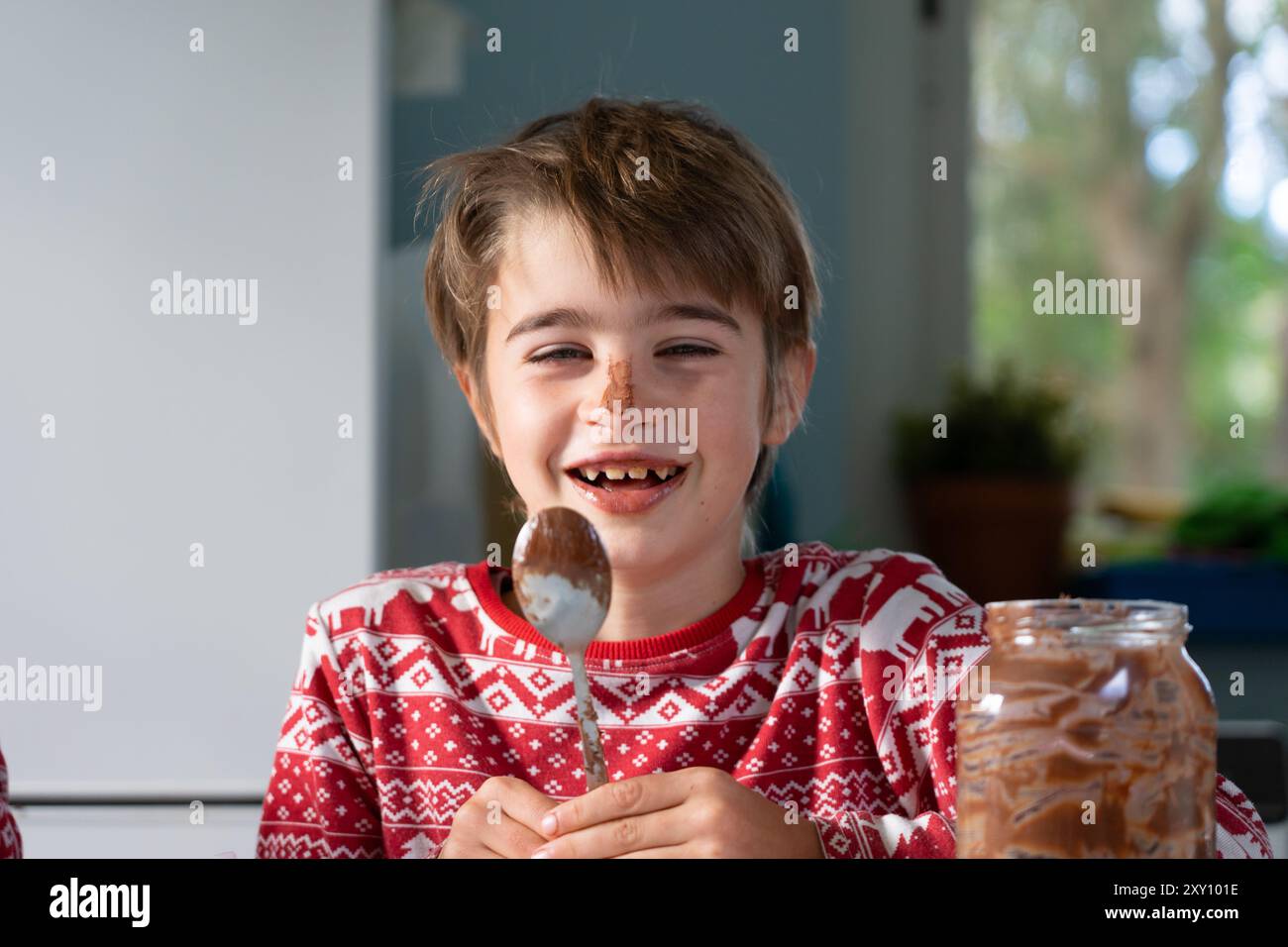 Portrait of laughing Caucasian boy with chocolate smeared face while ...