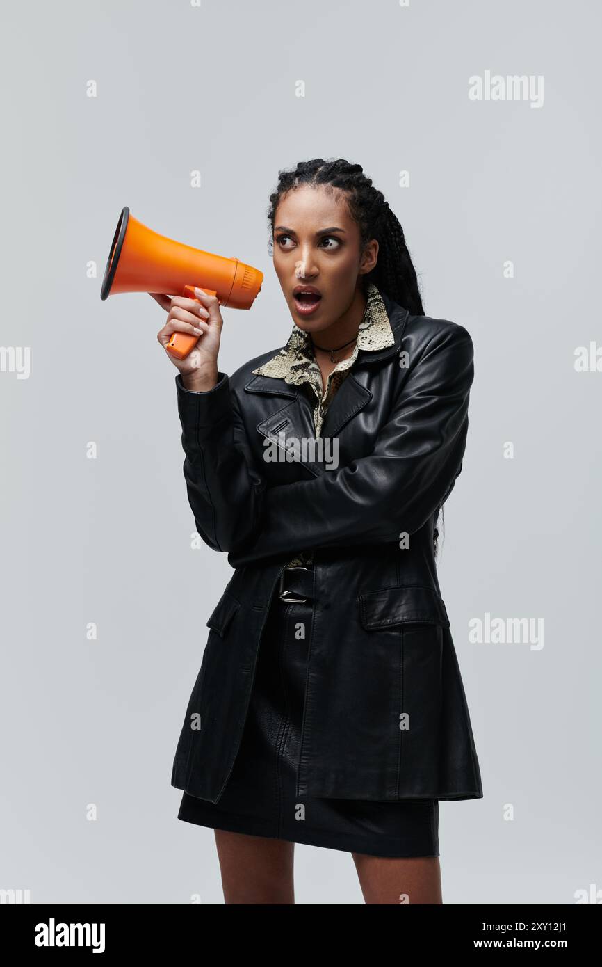 A woman with braided hair, in black leather and animal print, listens ...