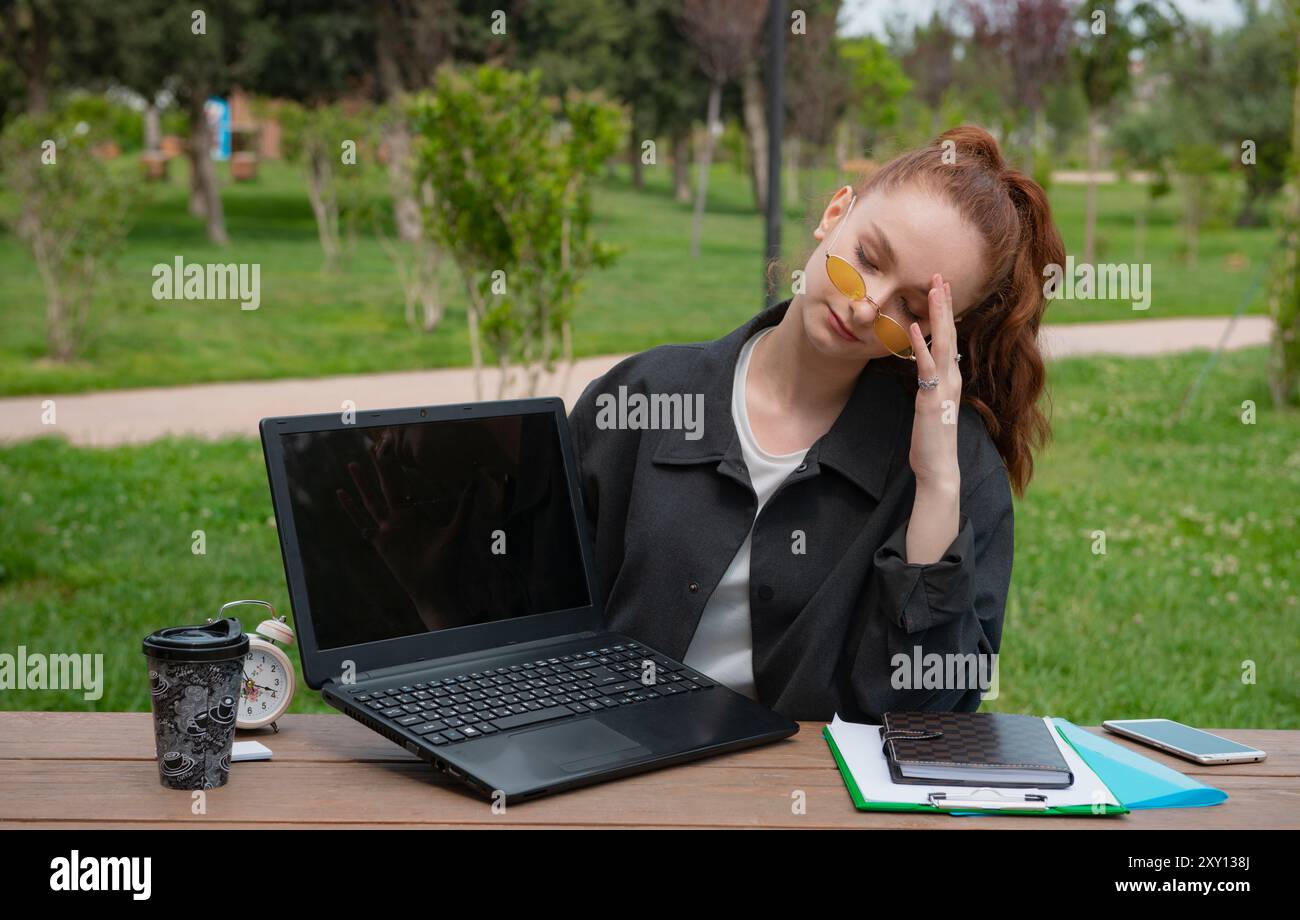 Tired girl working at laptop, showing screen, hand on forehead Stock ...