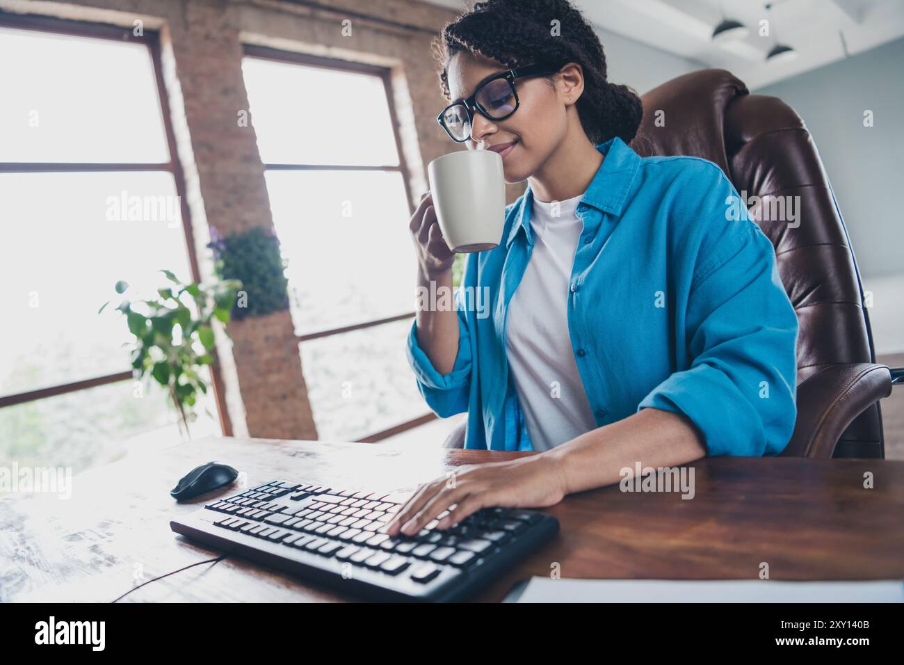Photo of attractive young woman working computer drink coffee wear blue ...